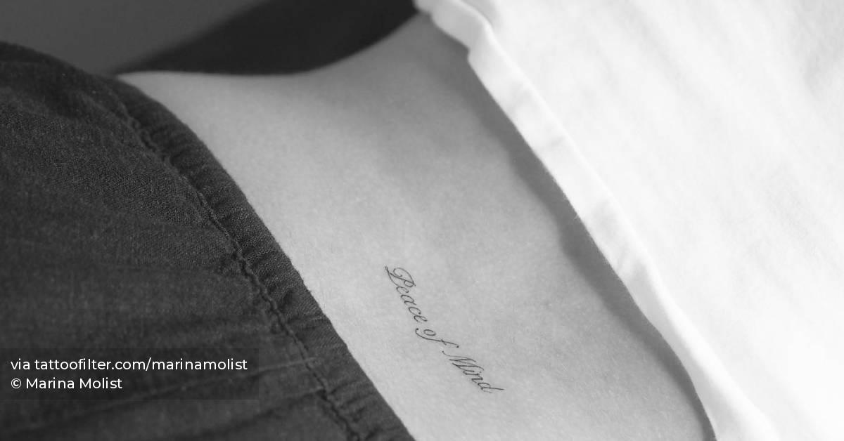 "Peace of mind" lettering tattoo placed on the lower