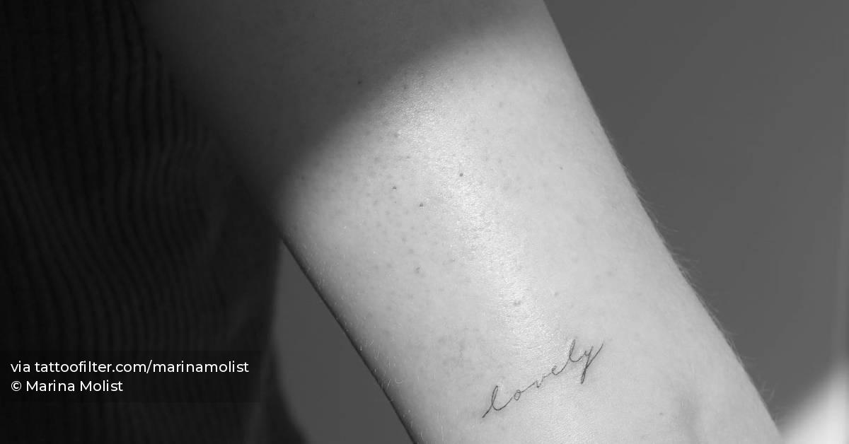 Tattoo of the word "lovely" handwritten on the tricep.