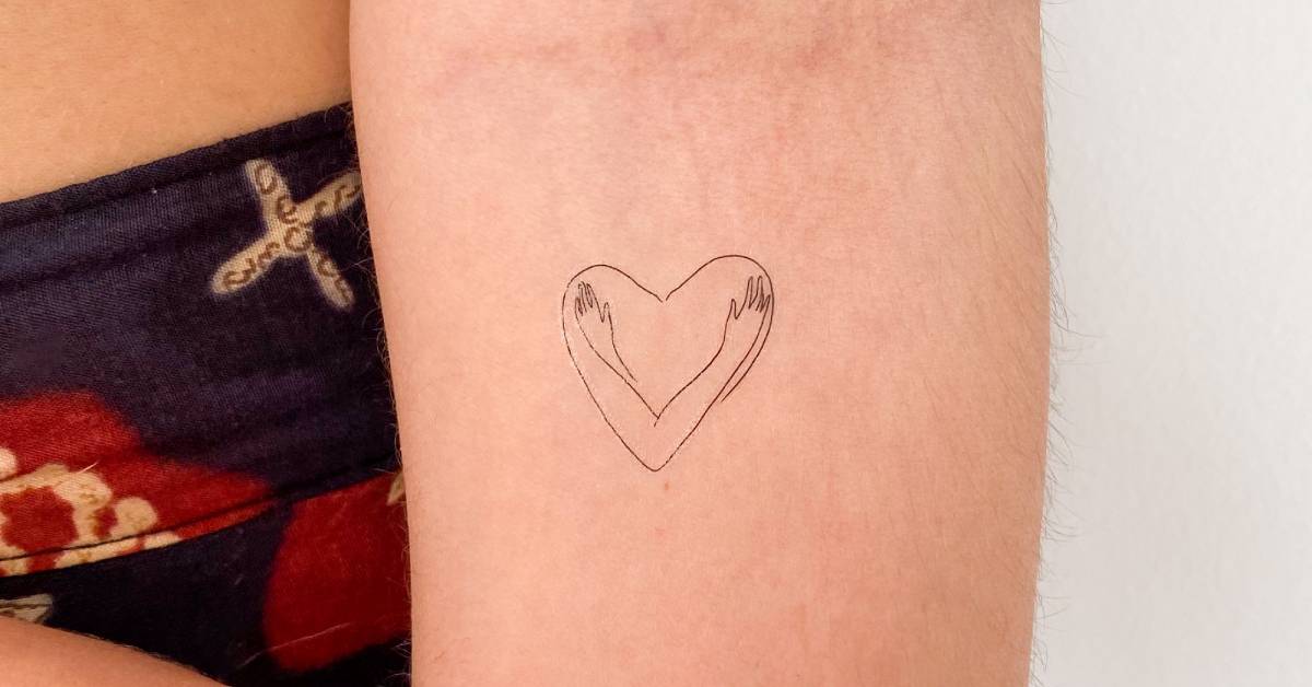Self hug temporary tattoo located on the inner forearm.