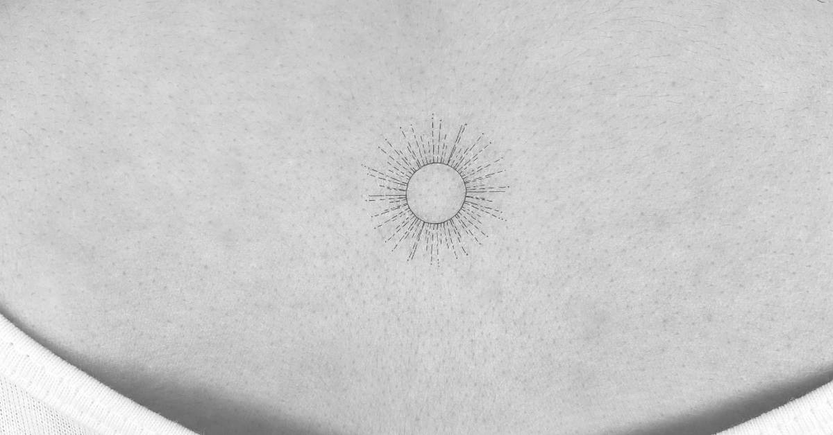 Shining sun temporary tattoo located on the upper back.