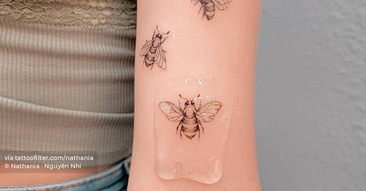 Fine line bees tattooed on the bicep.