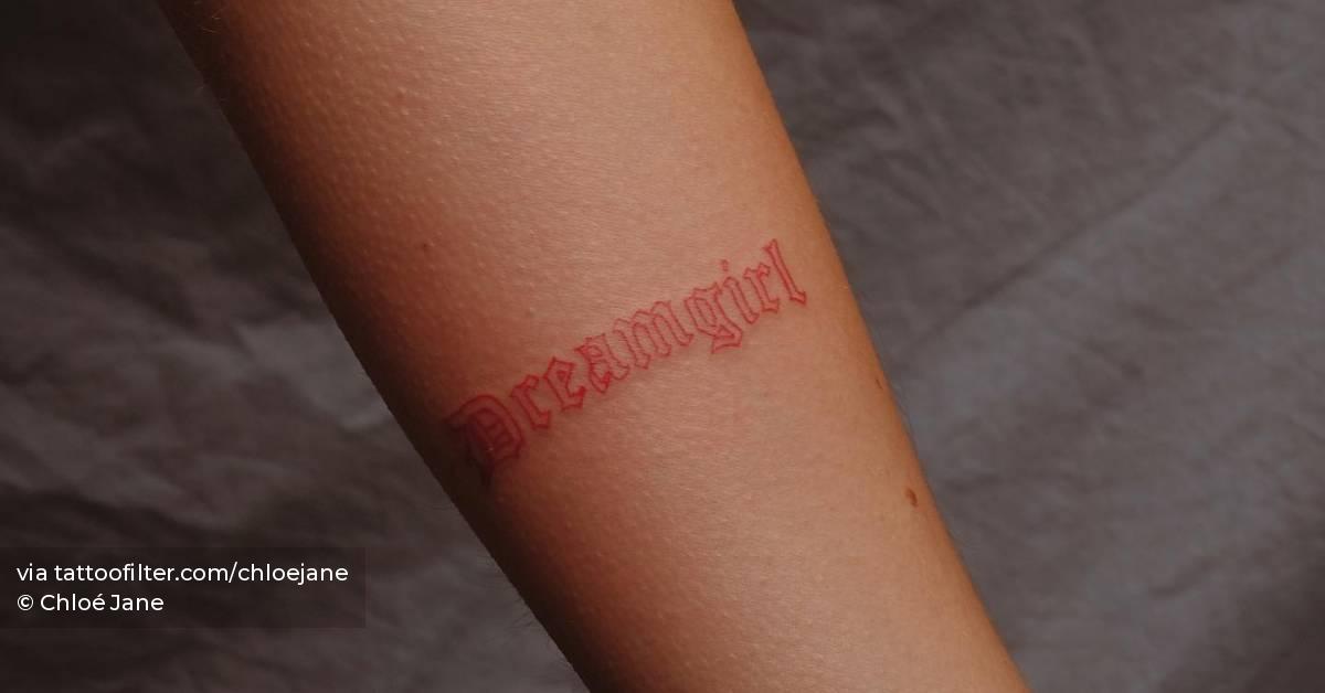 "Dreamgirl" red lettering tattoo located on the inner