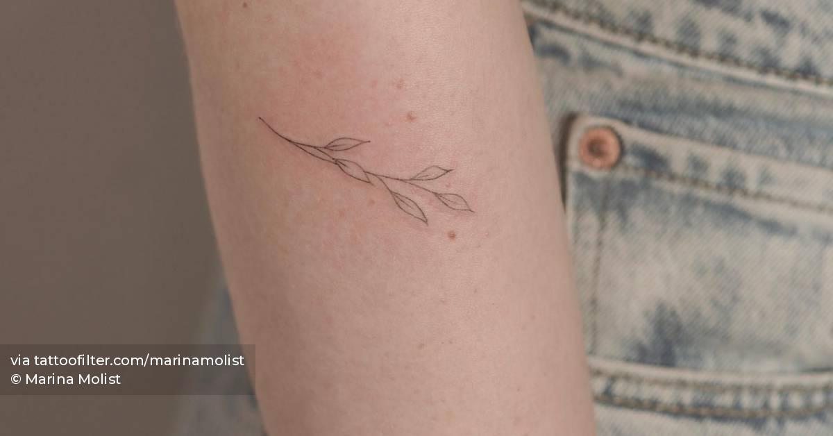 Fine line style leaves tattooed on the forearm.