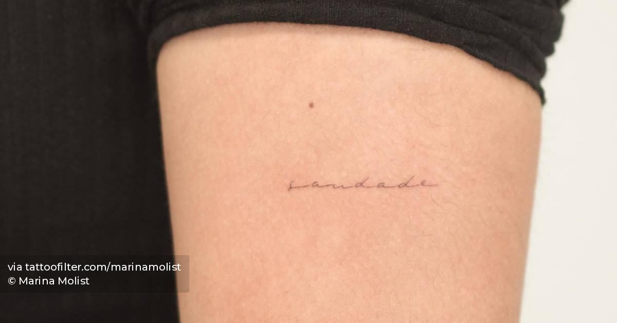 Tattoo of the word "saudade" handwritten on the inner