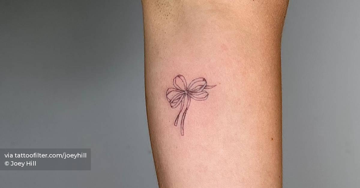 Fine line style ribbon tattoo done on the inner arm.