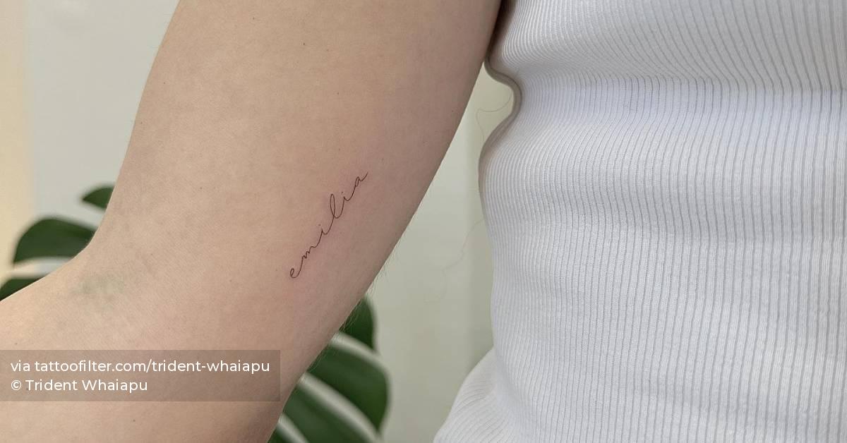 Tattoo of the name "Emilia" handwritten on the inner