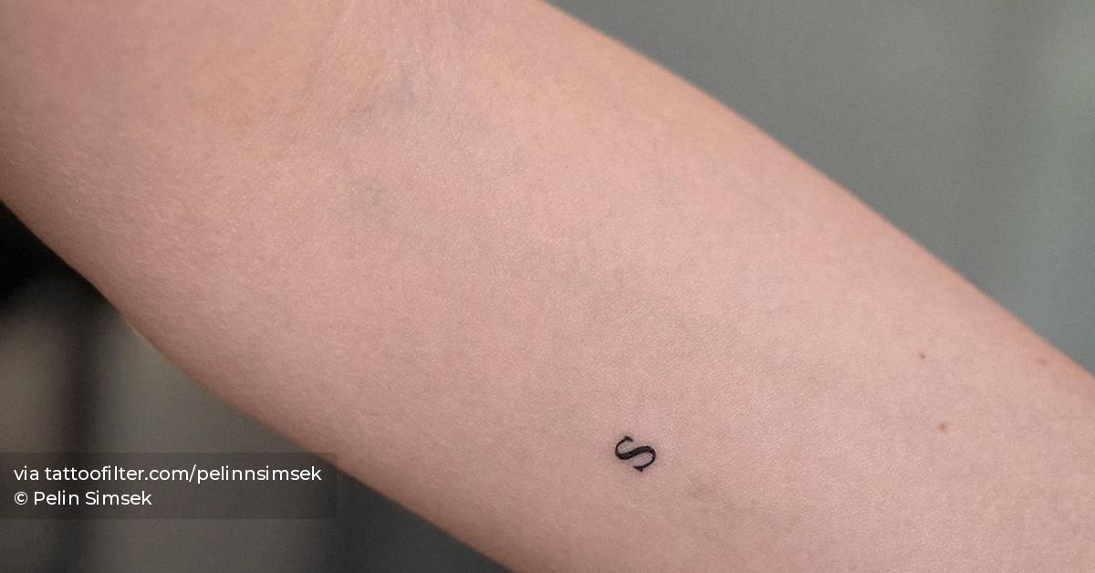 Minimalistic style tattoo of the letter "S" located on