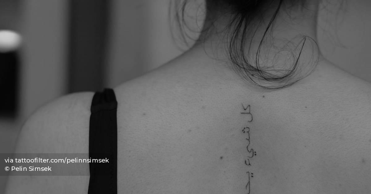 Arabic lettering tattoo located on the upper back.