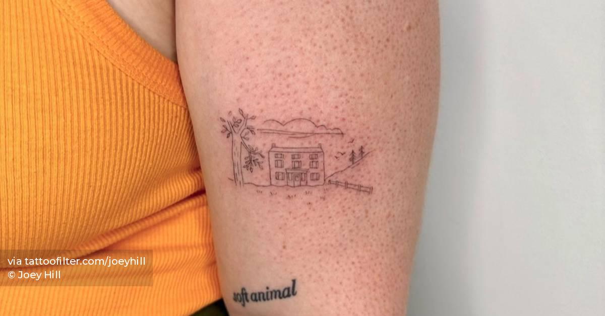 Fine line style house tattoo located on the upper arm.