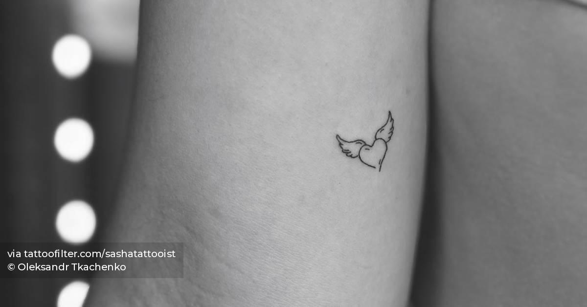 Fine line style angel wings and heart tattoo located on