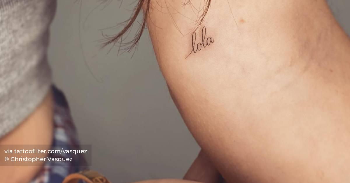 Tattoo of the name "Lola" placed on the inner forearm.