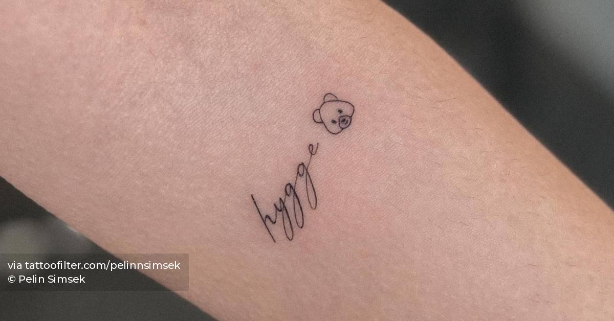"Hygge" and little bear head tattooed on the inner