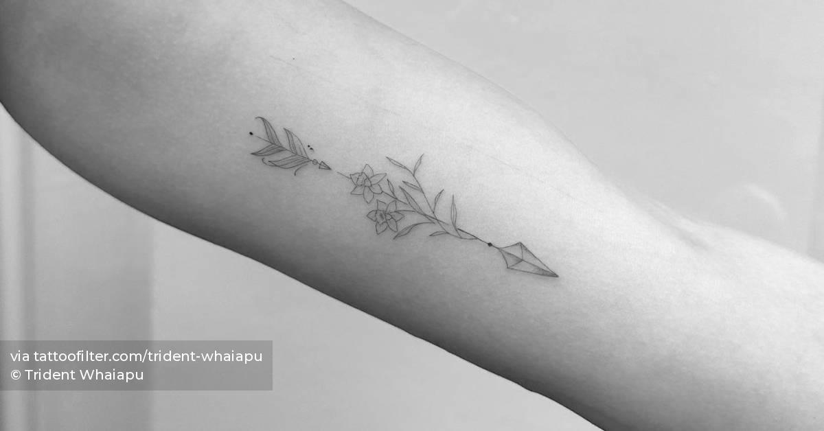 Floral arrow tattoo located on the inner arm,