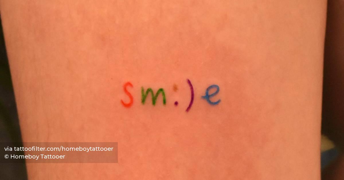 Colorful tattoo of the word "smile" a little smiley
