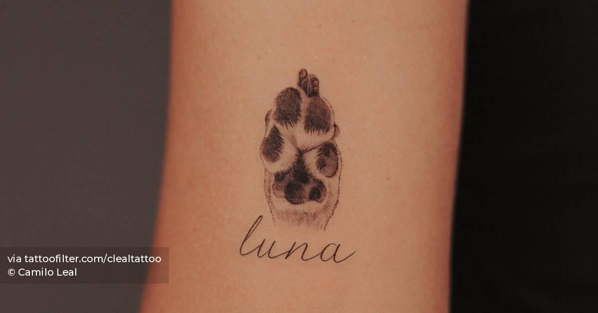 Micro-realistic dog paw and name "Luna" tattooed on the