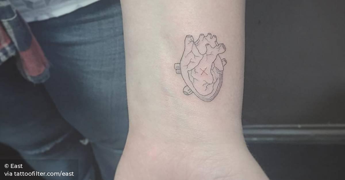 Fine line style heart tattoo on the left inner wrist.