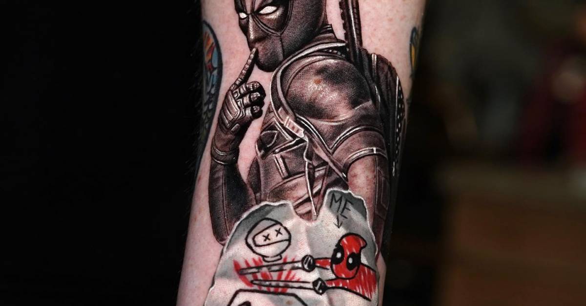 Deadpool tattoo located on the wrist, cartoon style.