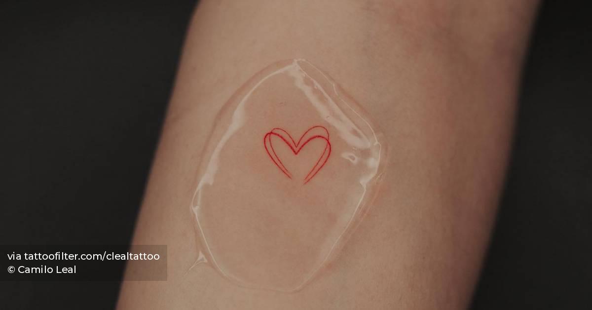 Minimalistic style red heart tattoo located on the