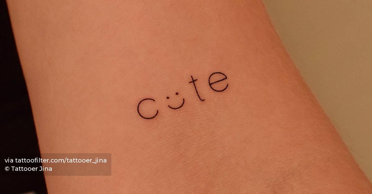 Tattoo of the word "cute" with a smiley face located on