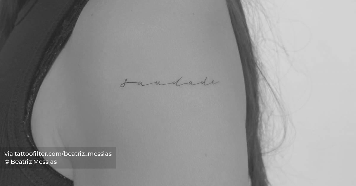 Tattoo of the word "saudade" handwritten on the upper