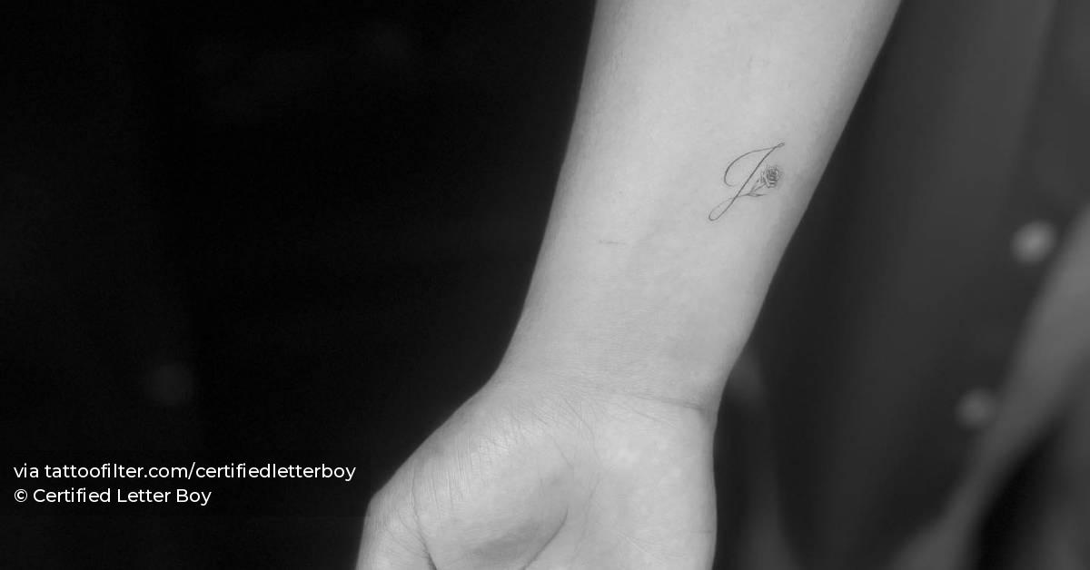 Letter "J" and flower tattoo located on the wrist.