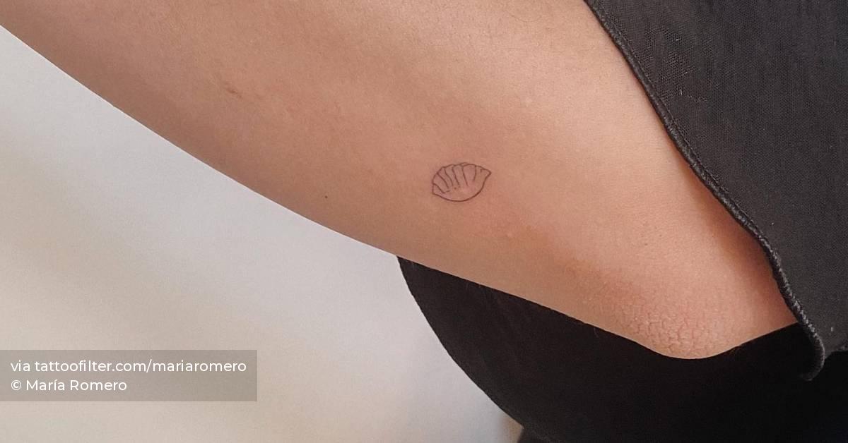 Micro scallop shell tattoo located on the forearm,