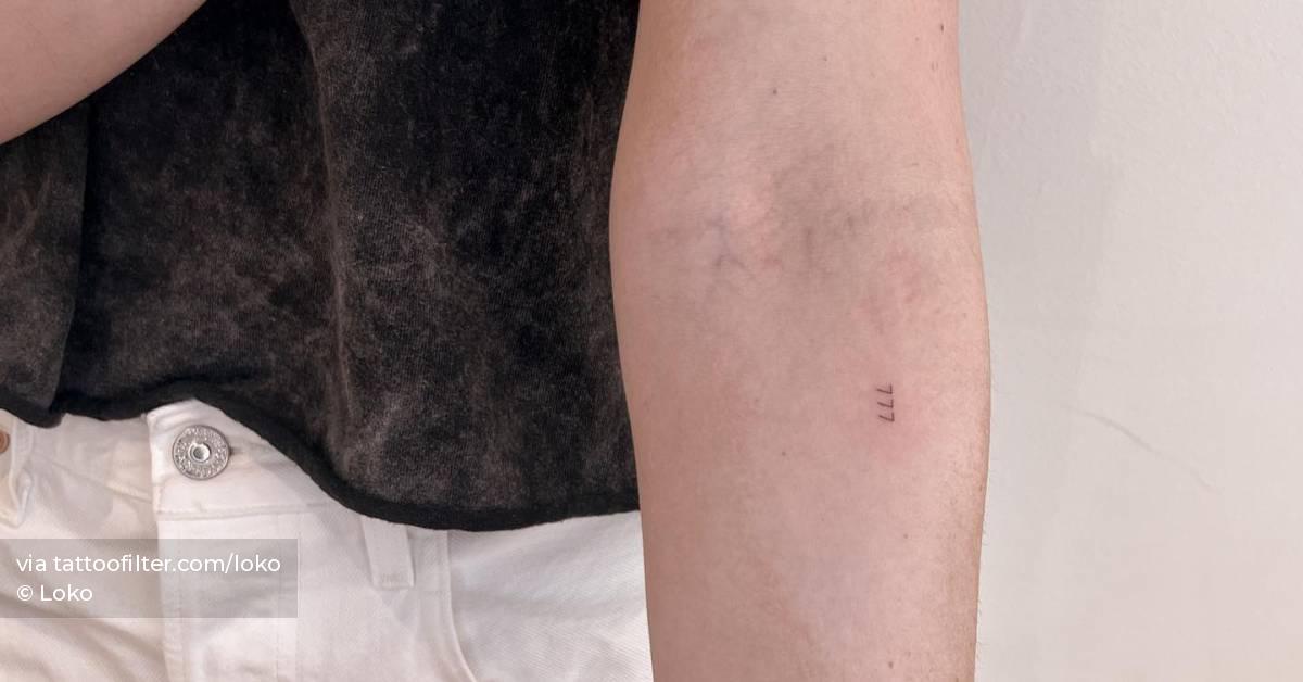 Tiny tattoo of the number "777" located on the inner