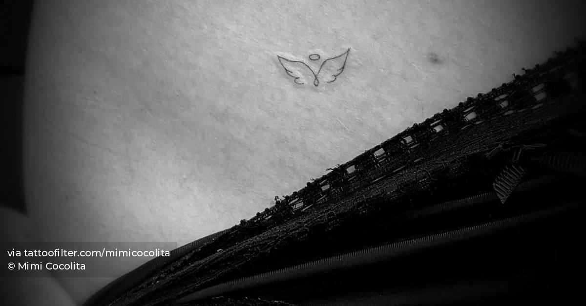 Fine line angel wings and halo tattoo located on the