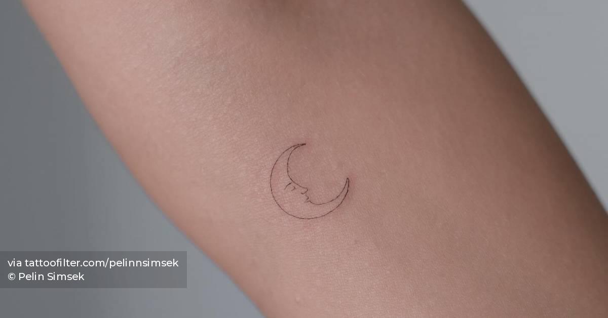 Fine line style moon face tattoo located on the inner