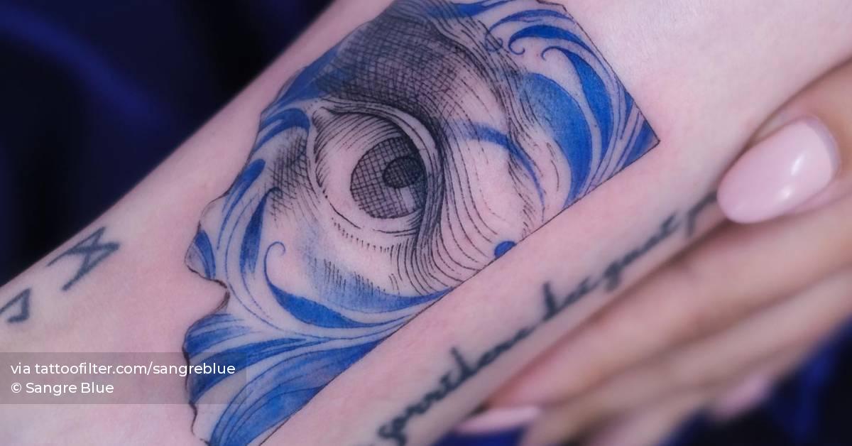 Porcelain eye tattoo located on the inner arm.