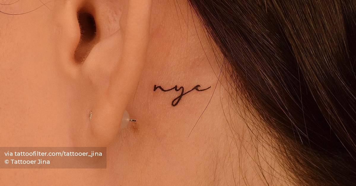 "NYC" lettering tattoo located behind the ear.