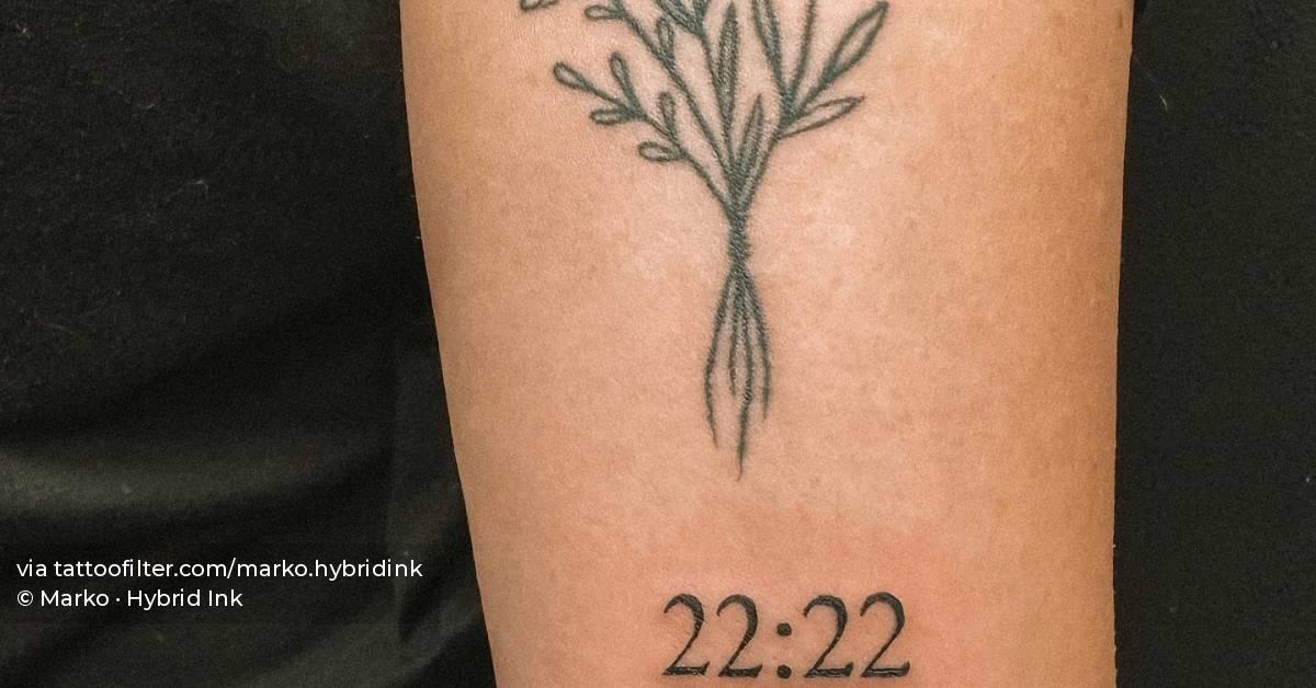 Angerl number "22:22" tattooed on the inner forearm.