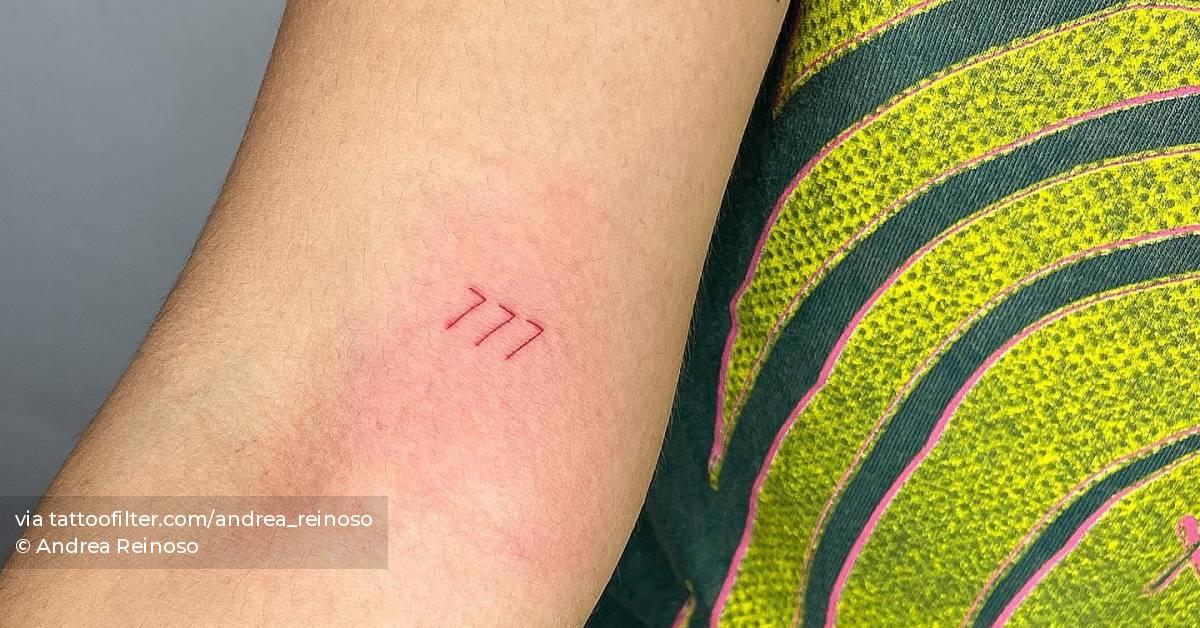 Tattoo of the number "777" in red ink located on the
