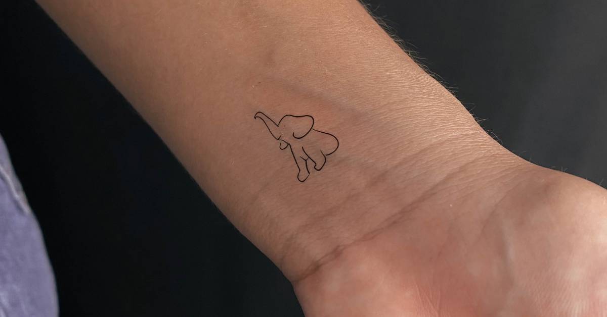 Fine line elephant temporary tattoo on the inner wrist.