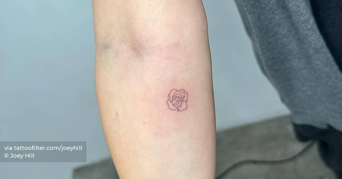 Single needle minimalistic rose head tattoo located on