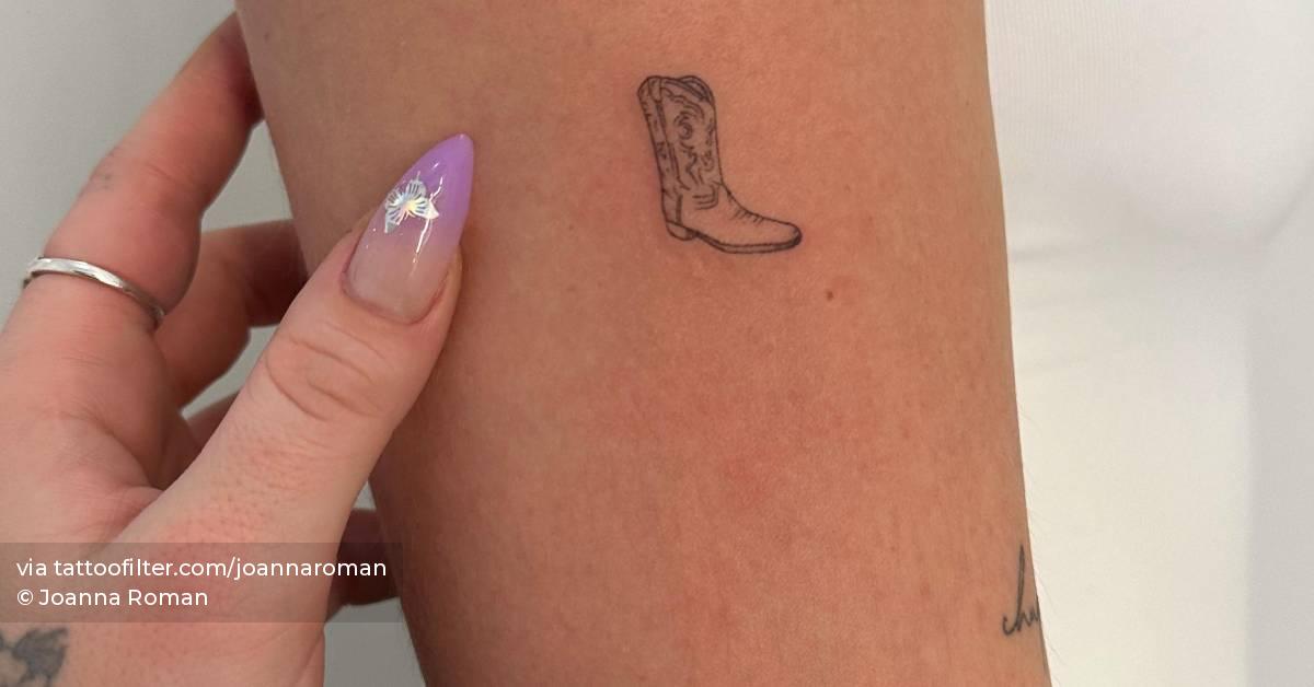 Fine line style cowboy boot tattoo located on the upper