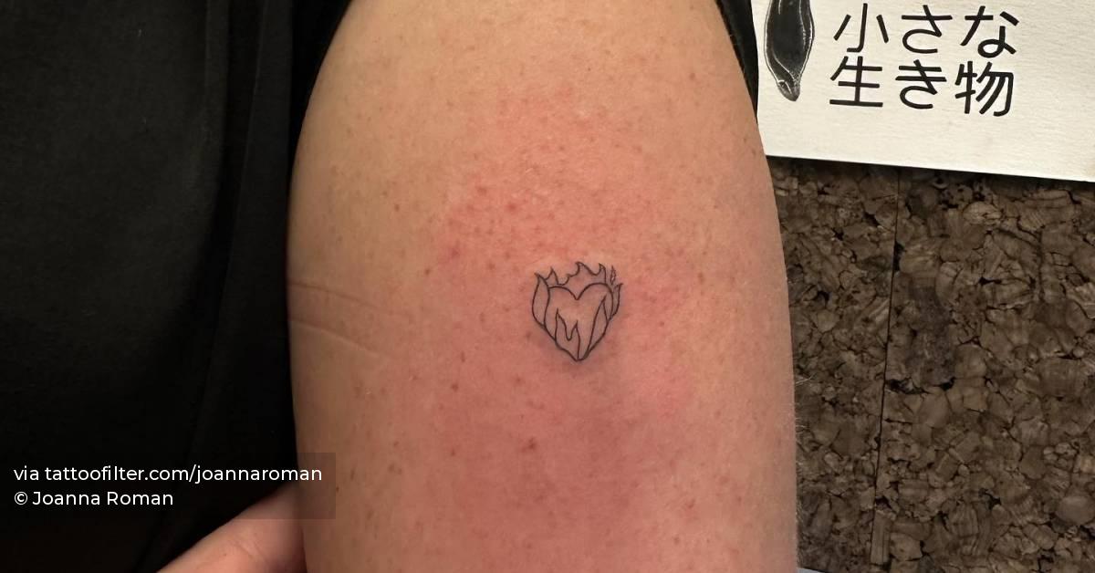Little flaming heart tattoo located on the upper arm.