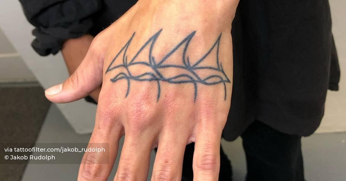 Healed geometric line art tattoo located on the hand.