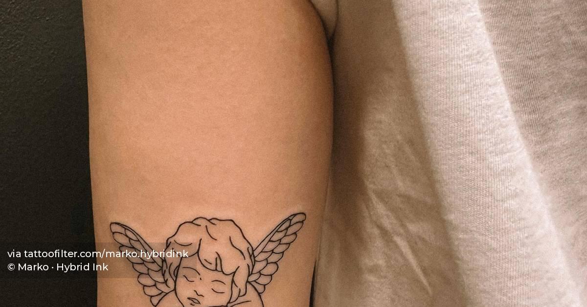 Fine line style cherub tattoo located on the tricep.