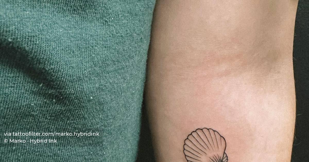 Fine line style scallop shell tattoo located on the