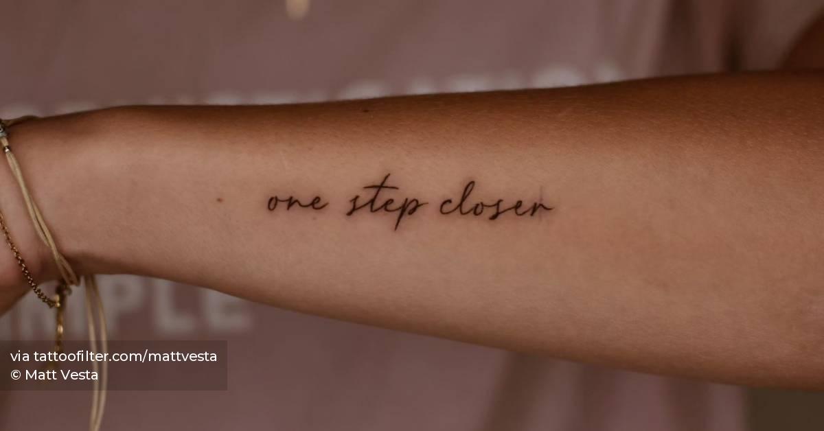 "One step closer" lettering tattoo handwritten on the