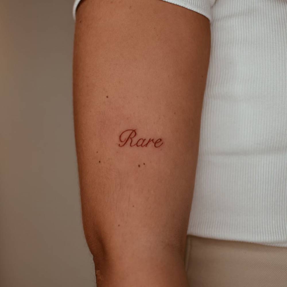 Tattoo Of The Word rare Located On The Upper Arm 