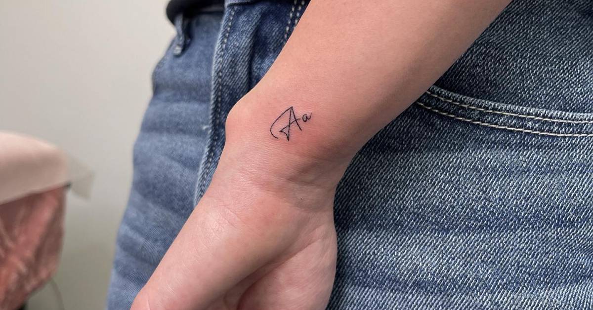 Minimalistic letter "A" tattoo placed on the wrist.