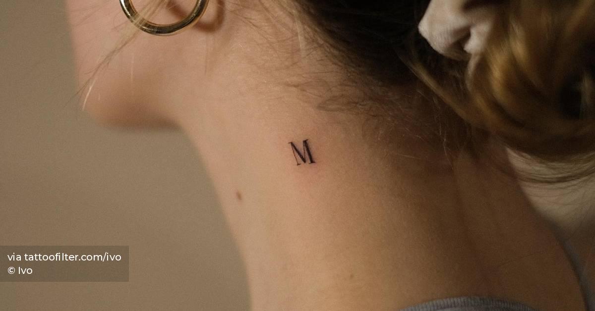 Minimalistic style letter "M" tattoo placed on the