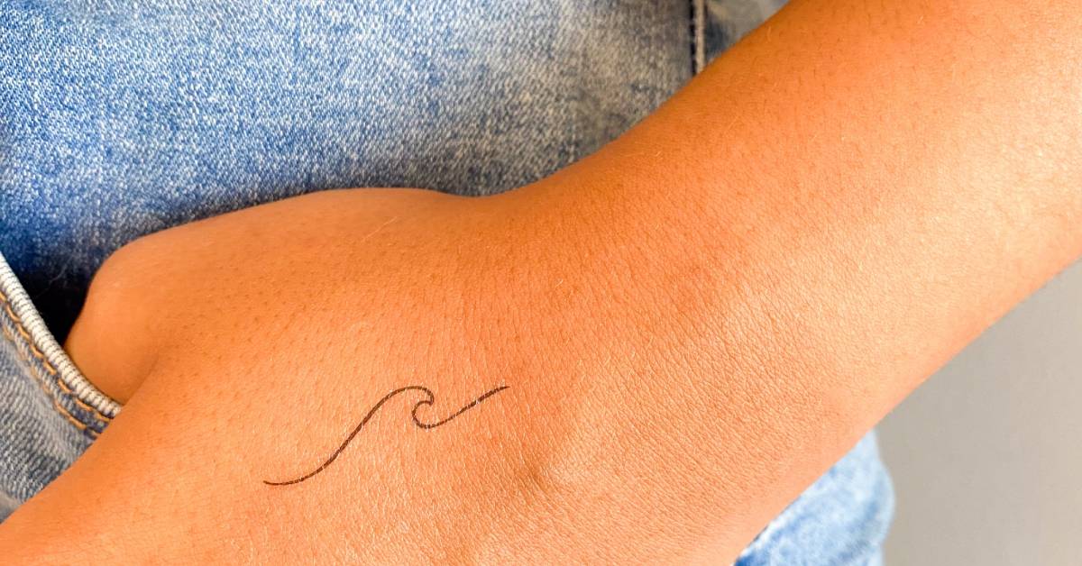 Minimalist wave temporary tattoo located on the hand.