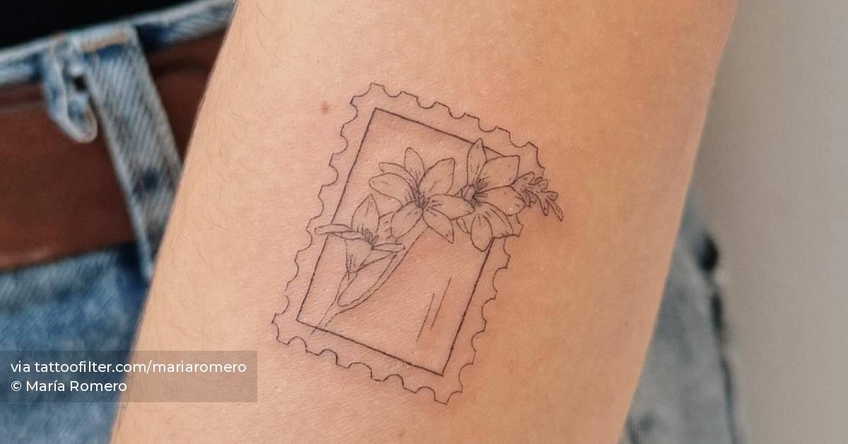 Fine line style lily stamp tattoo located on the