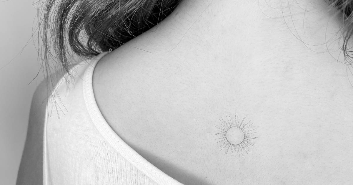 Shining sun temporary tattoo located on the upper back.