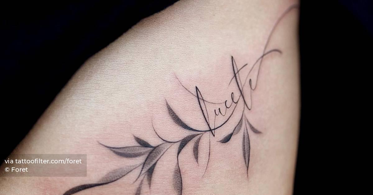 Word "lucete" and leaves tattoo located on the rib.