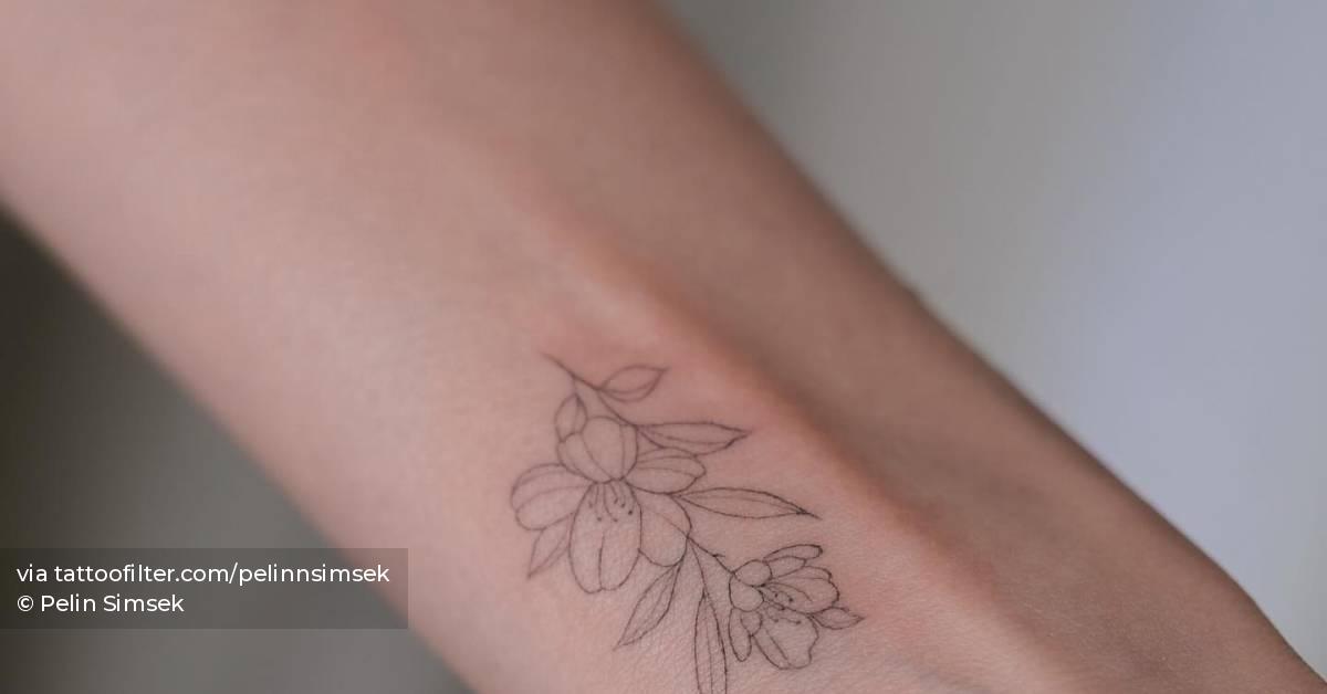 Fine line style flower tattoo placed on the wrist.