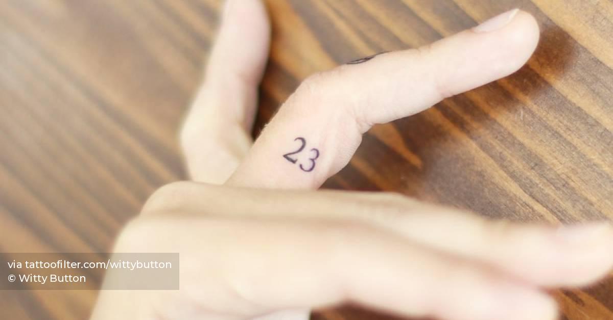 Tiny tattoo of the number "23" located on the finger.